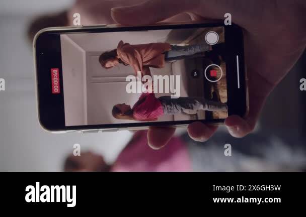 A hand of woman photographer holds a smartphone, takes a video and ...