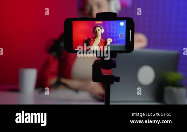 Female vlogger using microphone and headphones to record vlog for ...