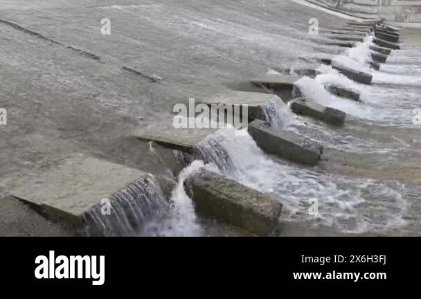 row of chute dentate blocks in concrete water spillway channel slope ...