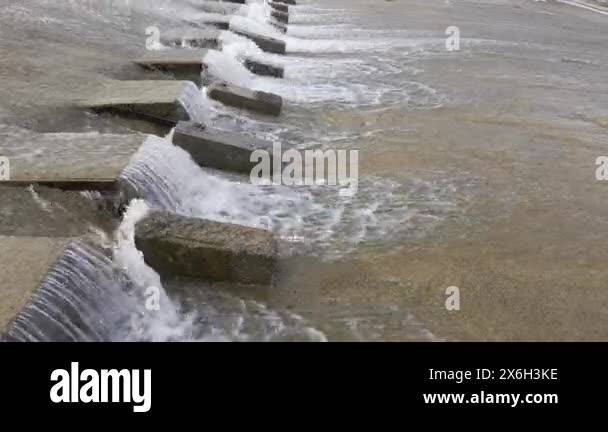 row of chute dentate blocks in concrete water spillway channel slope ...