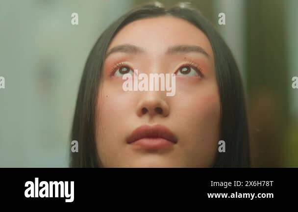 Close up Asian woman face young chinese korean faithful dreaming girl looking up calm peaceful ...