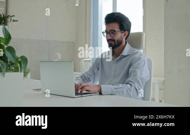 Arabian Indian muslim businessman ethnic man working with computer at corporate office cheerful ...