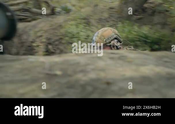 Two male soldiers or warriors in camouflage uniform and helmets sneak ...