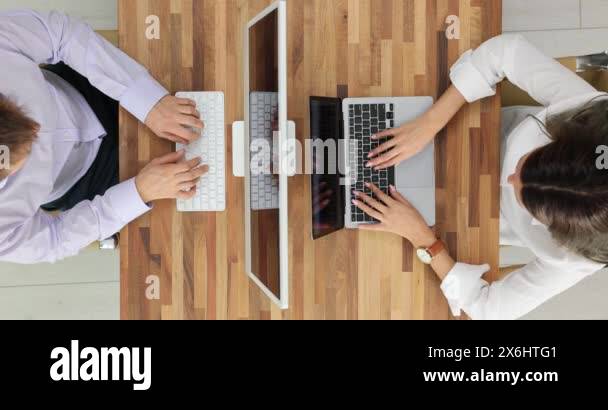 Couple of office workers shares workplace typing on computers. Woman ...