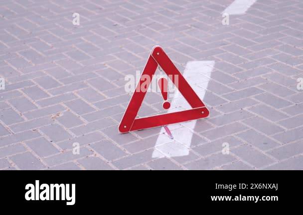 Red sign positioned on asphalt serves warning of impending accident ...