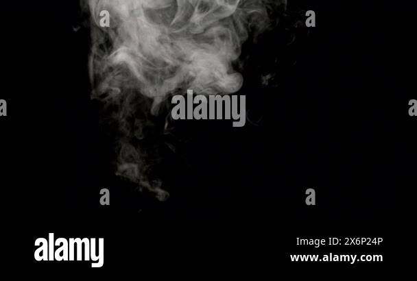 Wisps of smoke float in the air. The lighting highlights the smoke's ...