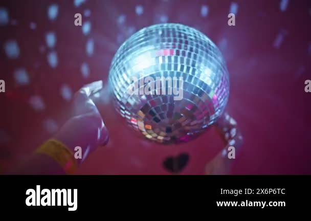 Hands touching disco ball sparkles with reflected light closeup ...