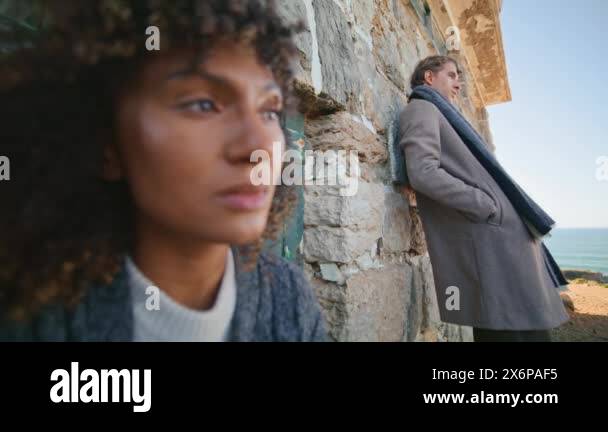 Romantic models posing rocks looking distance at ocean landscape ...