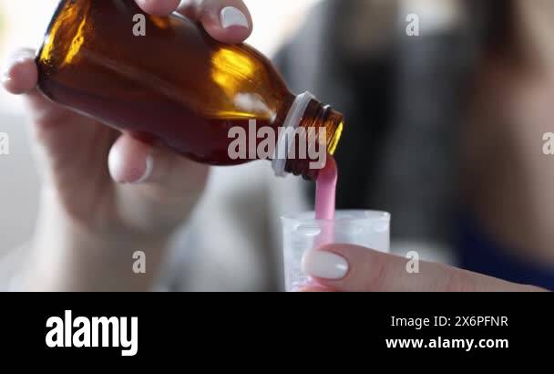Sick woman hands pouring cough syrup into measuring cup closeup 4k ...
