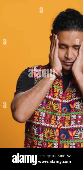 Vertical video Anxious indian man covering face with palms, worried ...