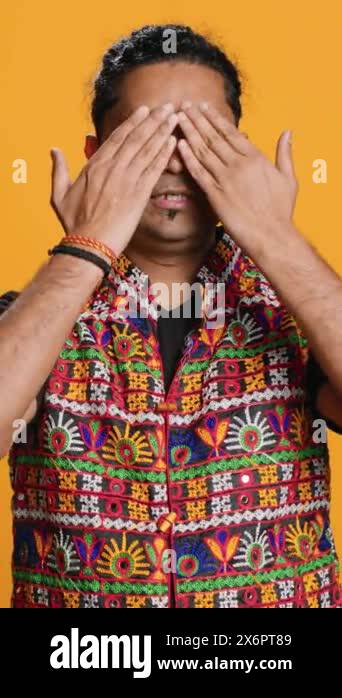 Vertical video Indian man covering eyes, ears and mouth with hands ...