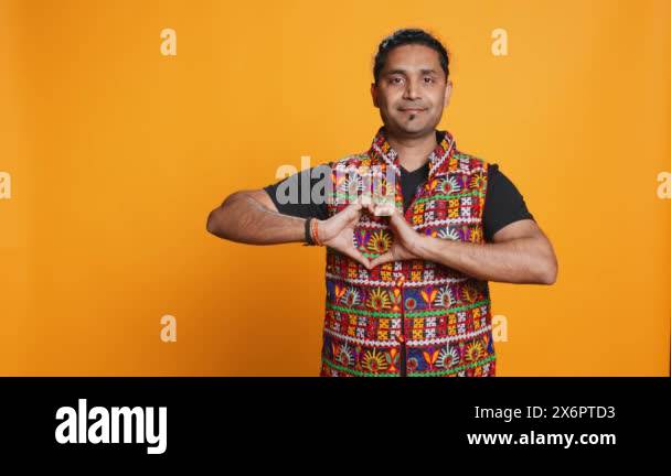 Portrait of jolly friendly indian man doing heart symbol shape gesture ...