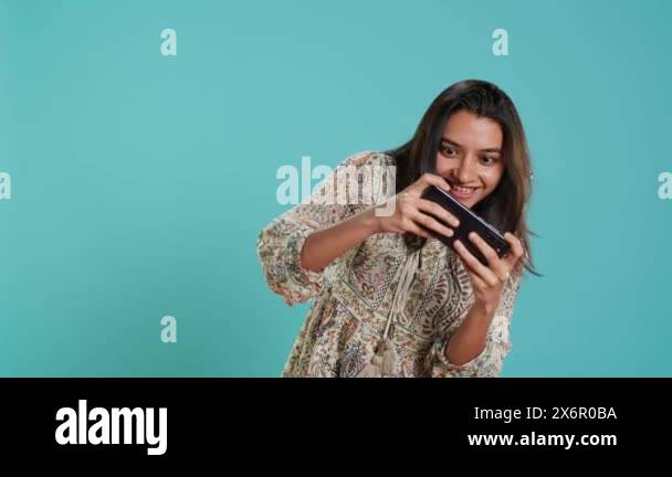 Delighted person playing intense mobile game, celebrating win, studio ...