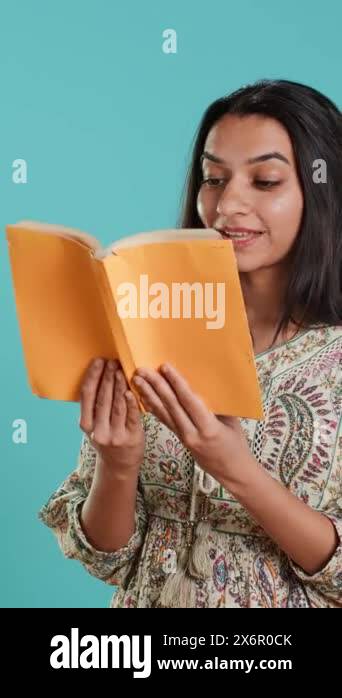 Vertical video Woman reading interesting book, enjoying hobby, being ...