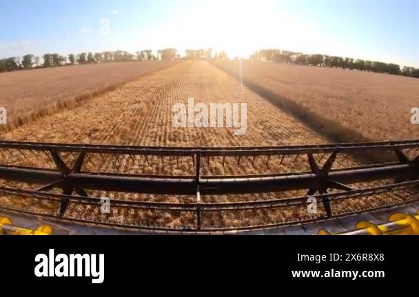 Combine riding through farmland after harvesting. View from harvester ...