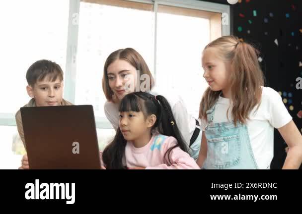 Young teacher looking at diverse student presentation in laptop and ...