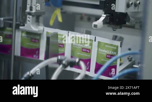 Manufacturing line at medical factory. Robotic arm put medicine package ...