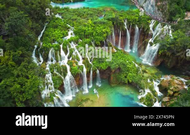Powerful waterfall flows into a lake with azure clear water. Plitvice ...
