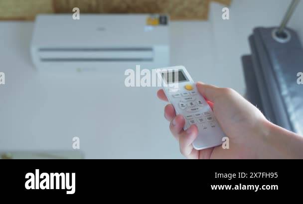 Human hand activating air conditioner with remote control counters heat ...