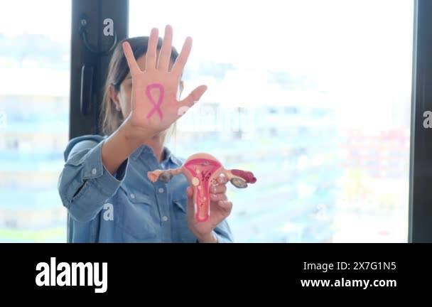 Woman showing cancer sign on her palm hand and uterus model Stock Video ...