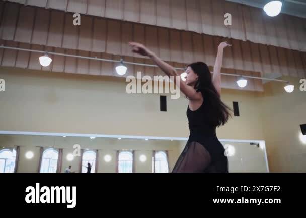 Ballerina in pointe shoes and black ballet dress shows beautiful dance ...