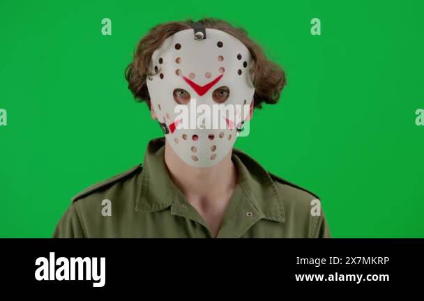 Maniac in hockey mask and jumpsuit shows gesture quietly ...