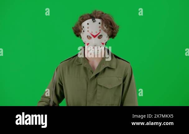 Maniac in hockey mask and jumpsuit with knife in hand shows gesture ...