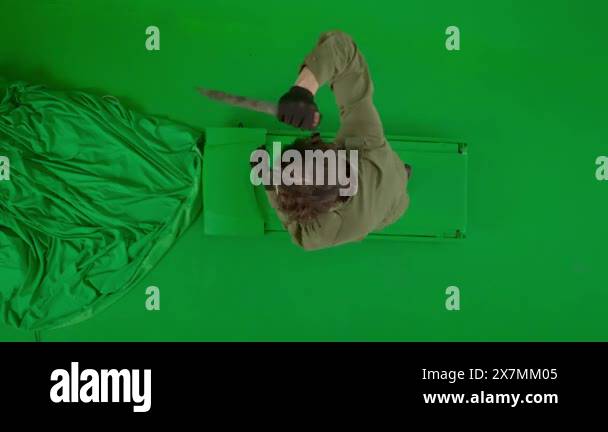 Maniac in hockey mask and jumpsuit running and waving a large sharp ...