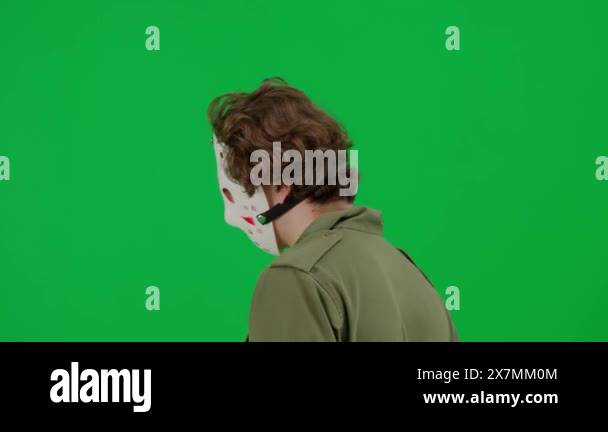 A maniac in a hockey mask folds his arms across chest and stares ...