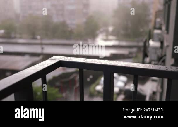 Rain dropping on railing. Close-up of rain drops falling in balcony ...