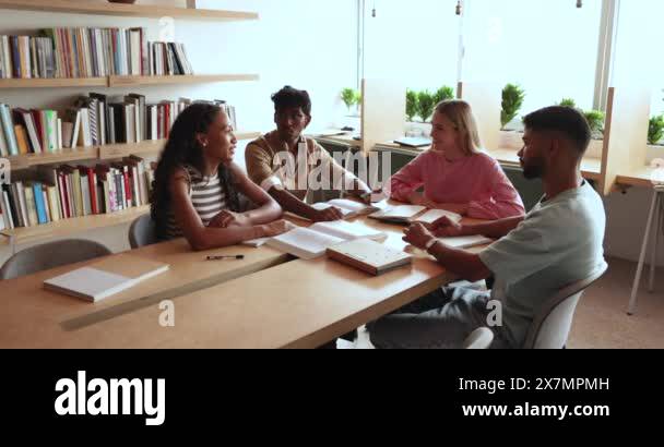 Four young girls and guys high-school students gather in library ...