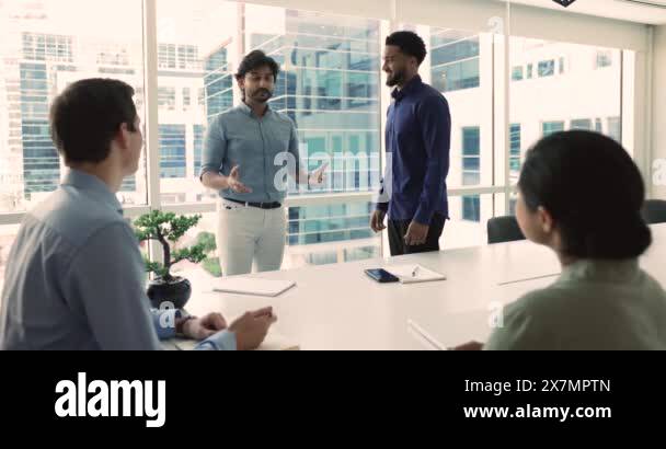 Indian male boss congratulate with promotion African employee, welcoming newcomer, praising ...