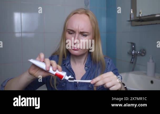 Toothpaste ingredients. Girl checks composition of toothpaste and is surprised by dangerous ...