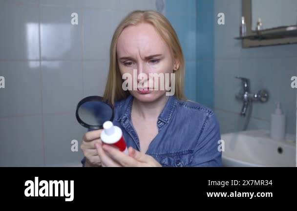 Toothpaste ingredients. Girl checks composition of toothpaste and is ...
