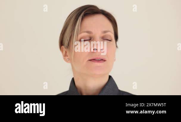 Woman with bright eyes makes grimace standing in premise. Female with ...