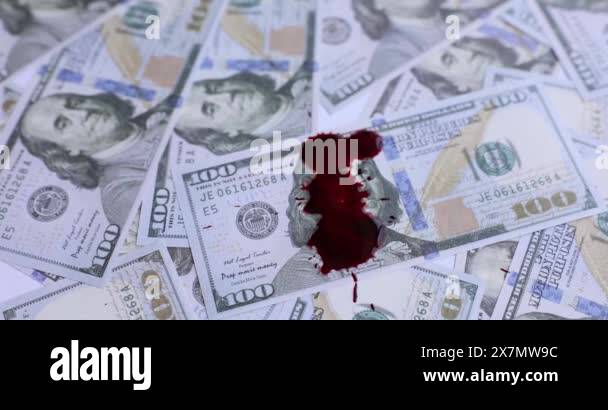 Drops of dark red blood fall on scattered dollar banknotes. Murder for ...