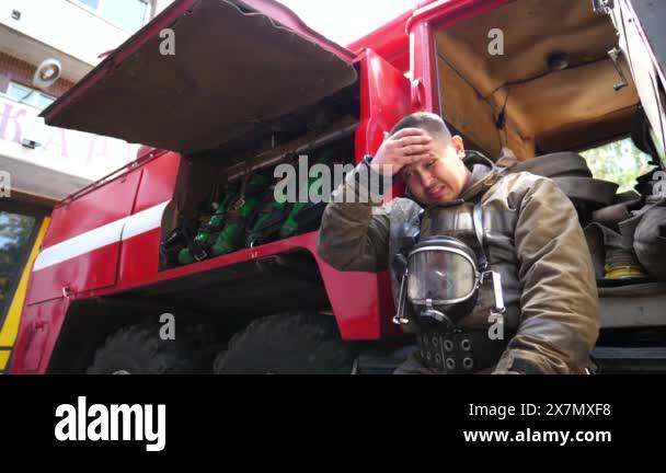 Male tired fireman wiping away the water on his hair and face after ...