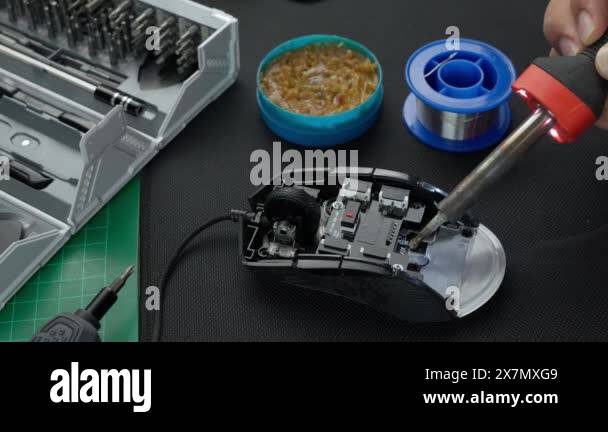 Mexican technician soldering electronic components of a mouse with ...