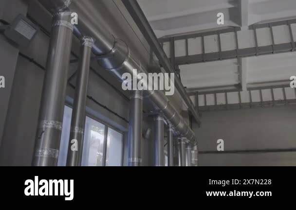 Steel gas distribution piles near window in plant workshop. System of ...