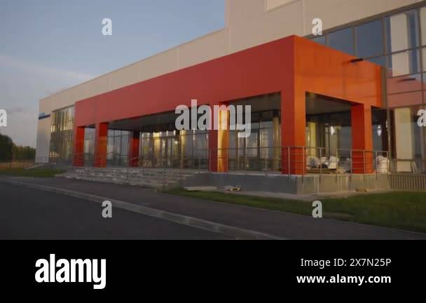Red entrance with columns and glass doors at shopping center. Modern ...