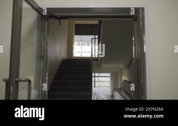 Shady staircase with metal handrails in future office building. Empty ...