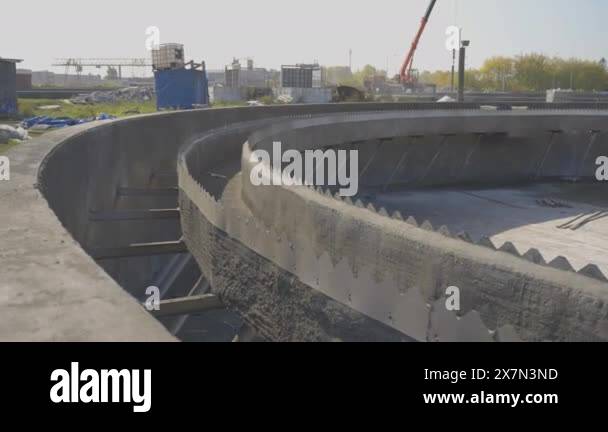 Unfinished aeration basin at backdrop of water treatment facility under ...