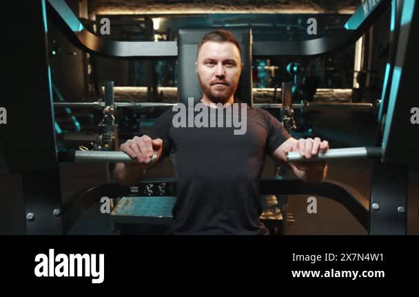A man is performing a weightlifting gesture in the gym, focusing on his ...