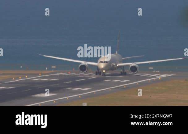 Modern widebody passenger aircraft at the start of the runway. Blue sea ...