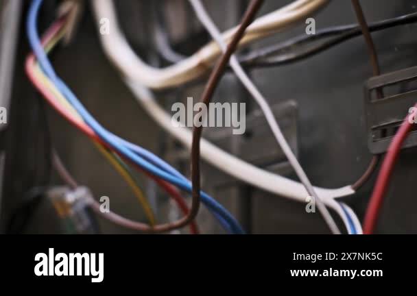 A close-up shot exposes damaged electrical wiring with visible burns ...