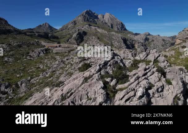 Explore the rugged terrain of a rocky mountain range from above ...