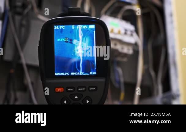 A thermal imaging camera reveals hotspots and temperature variations in an electrical panel ...