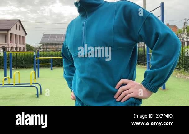 A focused young athlete dynamically performing warm-up drills and ...