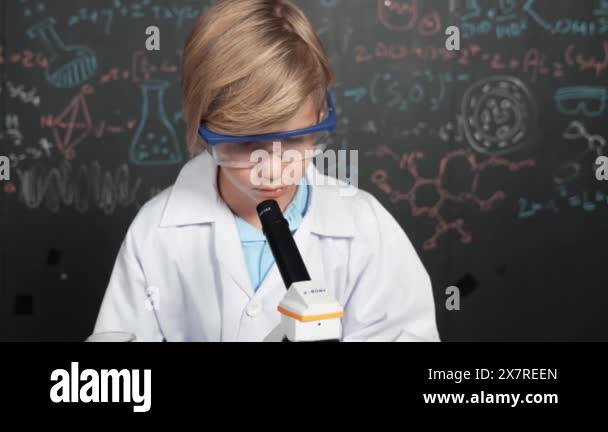 Smart boy using microscope analysis sample at science laboratory in STEM science class or ...