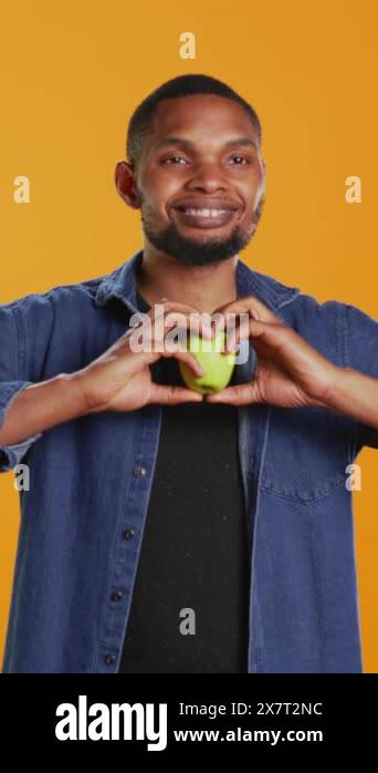 Vertical Video African american relaxed guy does a heart shape sign ...